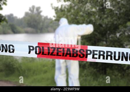 Symbolic image: Police cordon with forensics in the background Stock ...