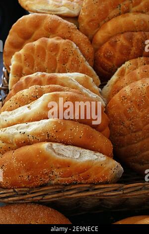 Close up several fresh flatbread loaves on retail display of bakery ...