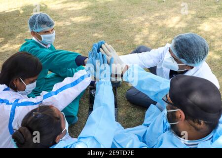 The Indian doctors high fiving each other while sitting on green grass ...