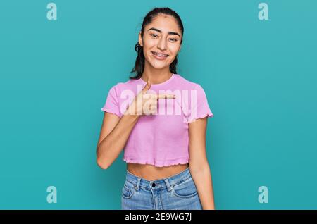 Teenager girl pointing her fingers to the side. Isolated background ...