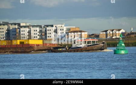 tug towing cory waste in sealed containers on barge in the river thames ...