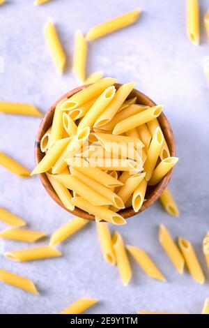 Raw pasta on grey background Stock Photo - Alamy