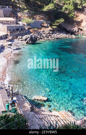 Waves crashing the rocky coast of Majorca mountains in the background ...