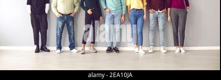 Cropped image of legs of different men and women standing in row in ...