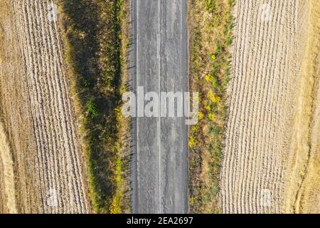 Rural road and patterns in cornfield after wheat harvest, aerial view ...