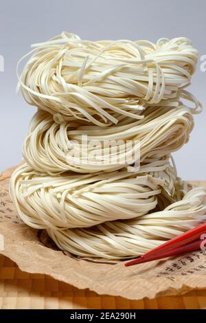 Chinese Yangchun noodles with chopsticks, uncooked, nest noodles Stock ...
