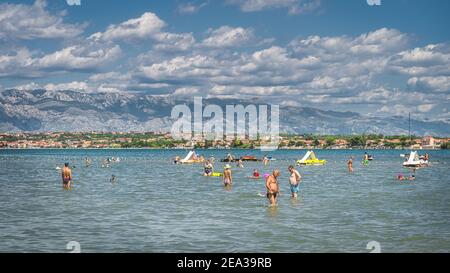 Nin, Croatia, July 2019 People relaxing and having fun in water of ...