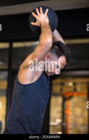 Fit man throwing medicine ball doing ball slam against gym floor or ...
