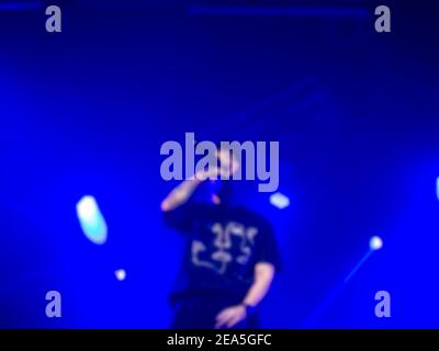 Blurred vocalist man, singer holding microphone and singing a song on ...