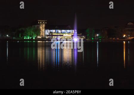 Colorful lights from building reflects on the lake water surface at ...