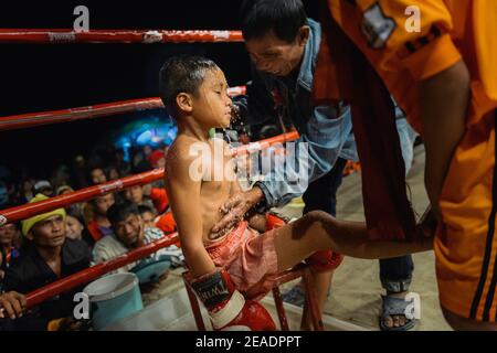 Trainer helps Muay Thai kid fighter between rounds Stock Photo - Alamy
