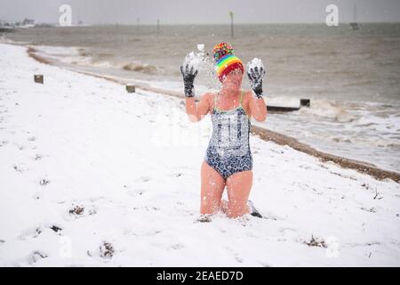 Early morning swimmer Victoria Carlin jumps in snow on the beach after ...