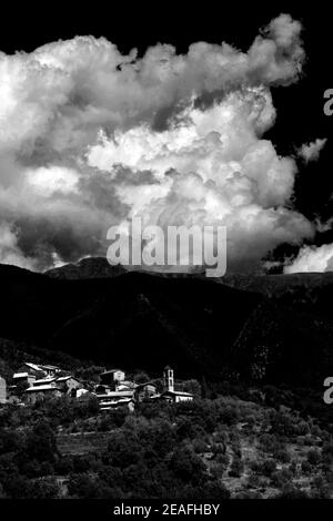 A grayscale shot of the clouds over the high forested mountains Stock ...