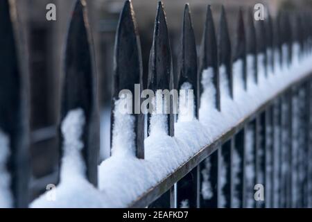 Metal fence covered with snow and frost crystals at sunset Stock Photo ...