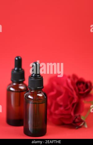 Bottles of cosmetic serum with herbal extract on green background with ...