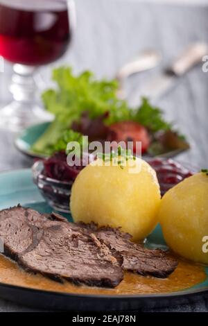 Plate of sauerbraten marinated beef with red cabbage and potato ...