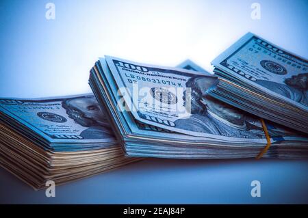 Banknotes of dollars in packs. Dark blue light Stock Photo - Alamy