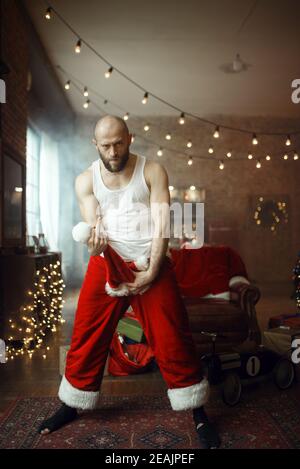 Bad shameless Santa with red hat between his legs Stock Photo - Alamy