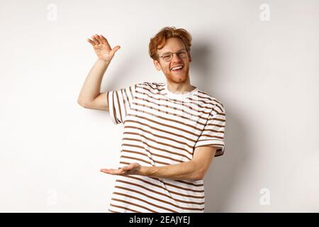 Smiling proud redhead guy showing empty laptop screen. Handsome young ...