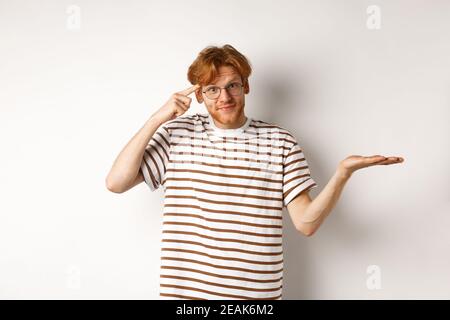 Are you stupid. Confused redhead guy in glasses shrugging, pointing at ...