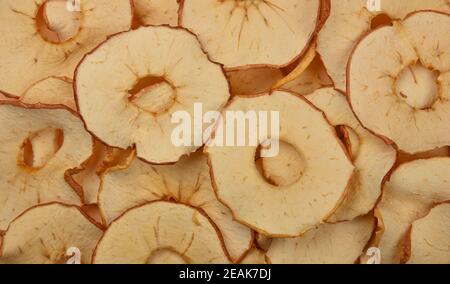 Close-up natural dried apple slices on white plate. Fruit chips ...