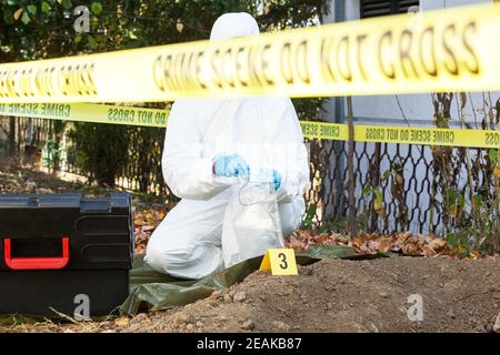 Investigator and criminologist working at crime scene outdoors, closeup ...