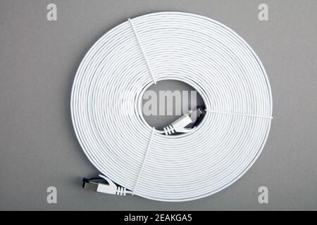 A coil of an Internet network cable for data transmission on a blue ...