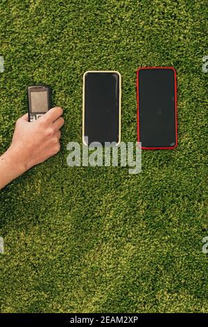 The Human Hand Picks an Old Phone That Lies Near New Smartphones Stock ...