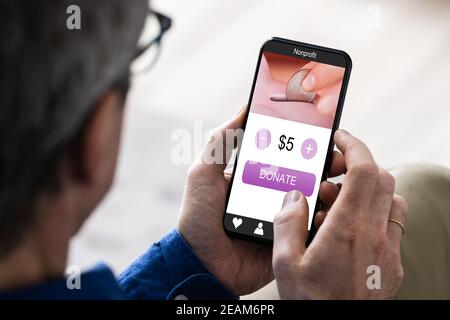 Man Using Online Money Donation App On Phone Stock Photo - Alamy