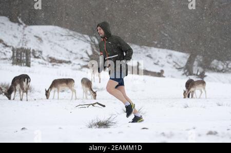 A person jogs in a park near Olympic Stadium during warm weather, in ...