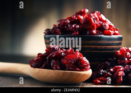 Composition with bowl of dried cranberries on wooden table Stock Photo ...