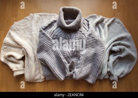 Three pastel warm sweaters for winter background. Women's stylish ...