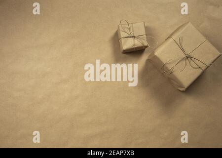 Two Gift boxes wrapped in plain brown paper with pink decoration and ...