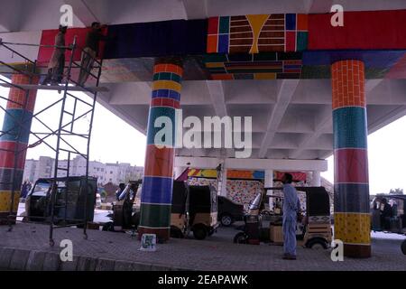 Laborers are busy in art painting on pillar wall of a bridge for the ...