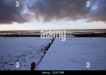 Snow falls on Whitstable beach in Kent, as the cold snap continues to ...