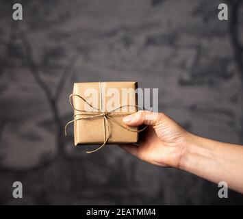 Wrapped christmas or other holiday handmade present in craft paper with ...