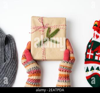 Hands hold gift box tied with rope on a beige background. Festive ...