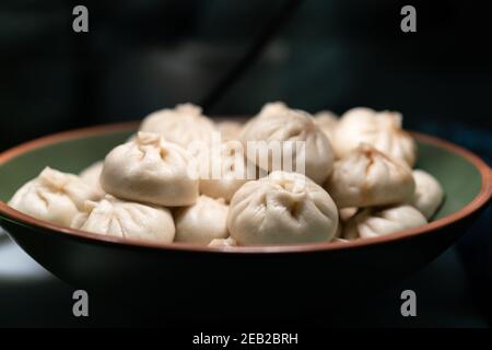 Closeup shot of a bowl of delicious homemade donuts isolated on a red ...