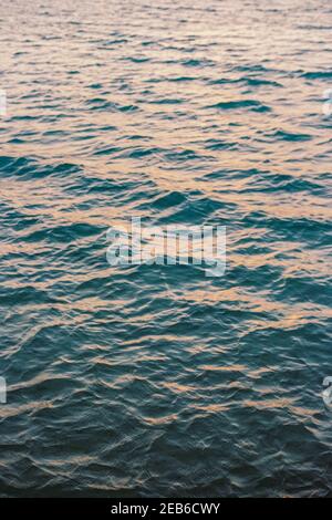 A vertical shot of seawater texture, sunlight reflecting on the surface ...