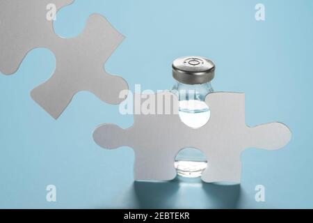 Vial of Covid-19 vaccine behind jigsaw puzzles Stock Photo - Alamy