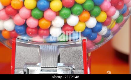 Traditional coin-operated gumball machine filled with multi coloured ...