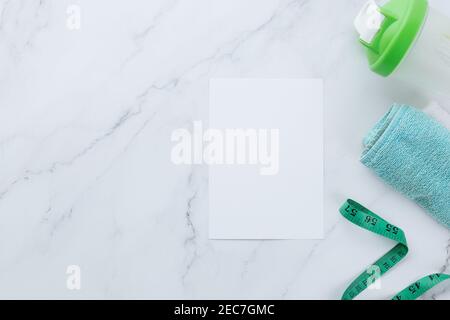 Blank white paper note and fitness equipments on white marble ...