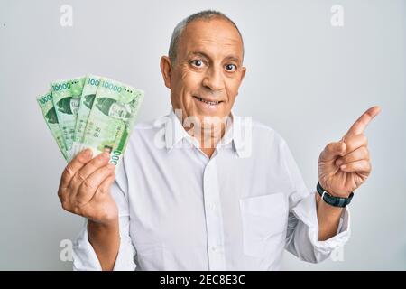 Handsome senior man holding 10000 south korean won banknotes doing ok ...
