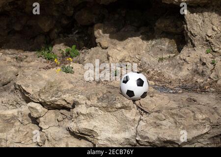 Football and the dark stone. Ball is situated on the rock Stock Photo ...
