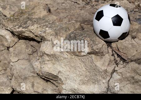Football and the dark stone. Ball is situated on the rock Stock Photo ...