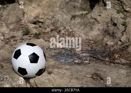 Football and the dark stone. Ball is situated on the rock Stock Photo ...