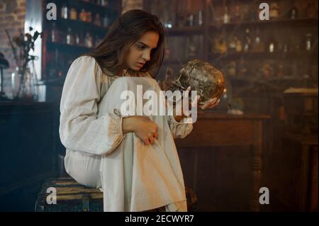 Scary demonic woman holds human skull, demons casting out. Exorcism ...