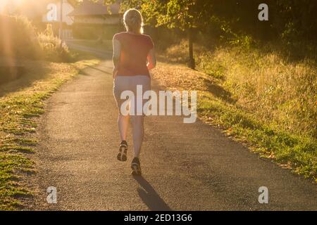Athletic woman running in countryside Stock Photo - Alamy
