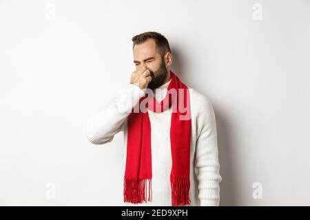 Displeased guy shut his nose from bad smell, grimacing disgusted ...