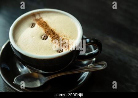 A cup of coffee with beautiful art from coffee beans and hand on a ...